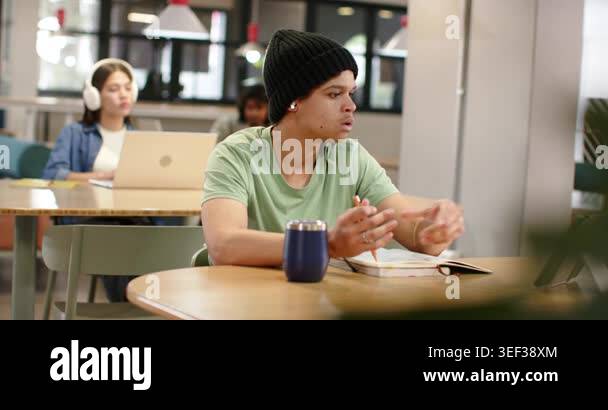 Adult African American man glancing at tablet, tapping stand, writing ...