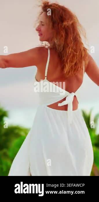 Portrait of beautiful happy woman in white and curly hair at beach at ...