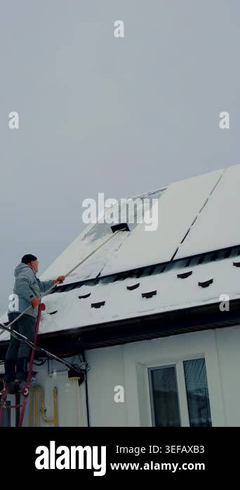 A man clears snow from solar panels. Selective focus. Nature Stock ...