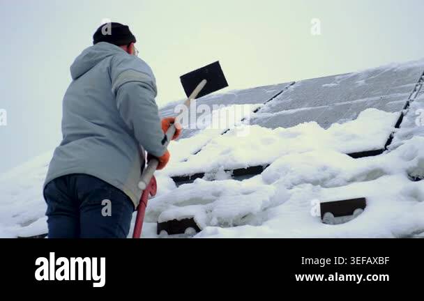 A man clears snow from solar panels. Selective focus. Nature Stock ...