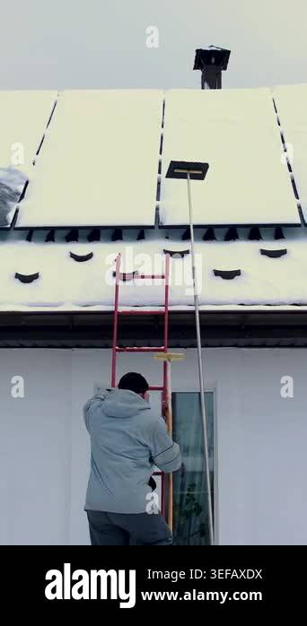 A man clears snow from solar panels. Selective focus. Nature Stock ...