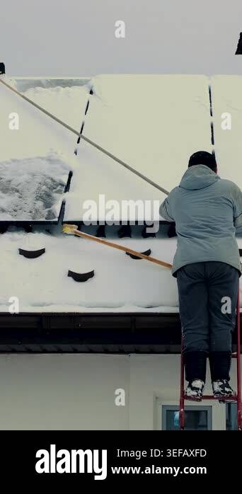 A man clears snow from solar panels. Selective focus. Nature Stock ...