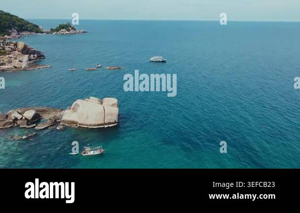 Aerial Rock And Turquoise Water With Small Boats Moored Nearby, Clear ...