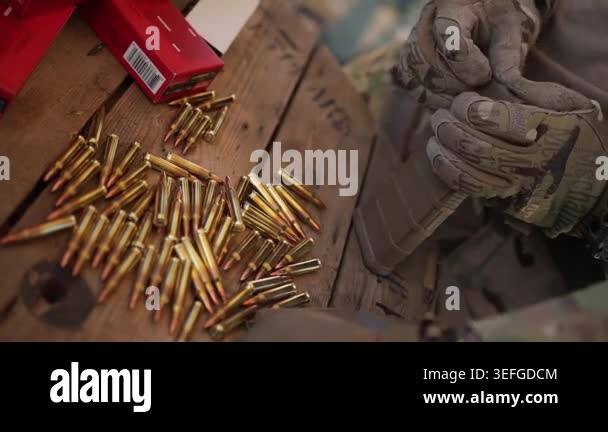 Male hands in military uniforms load a magazine with cartridges ...