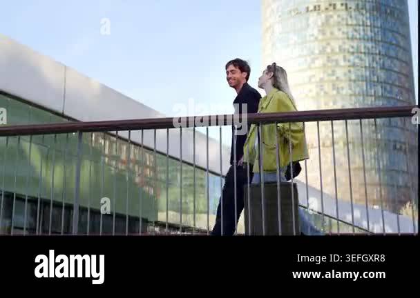 Young couple walking in Barcelona city with luggage, holding hands and ...
