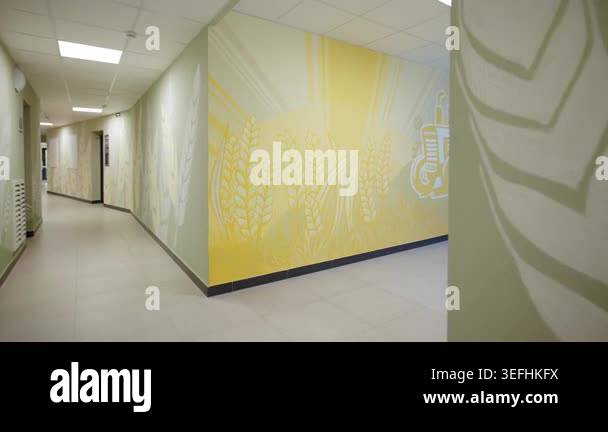 Corridor features mural depicting wheat stalks and rising sun. Tiled ...