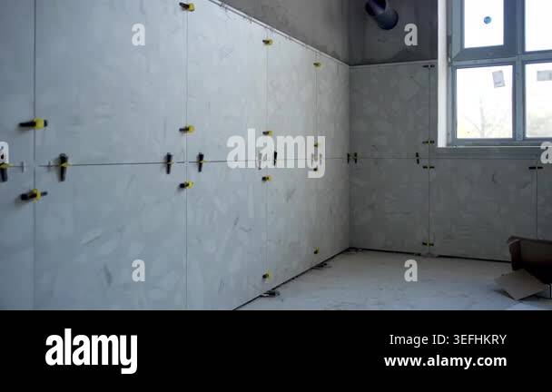 Large gray tiles with marble pattern cover walls during bathroom ...