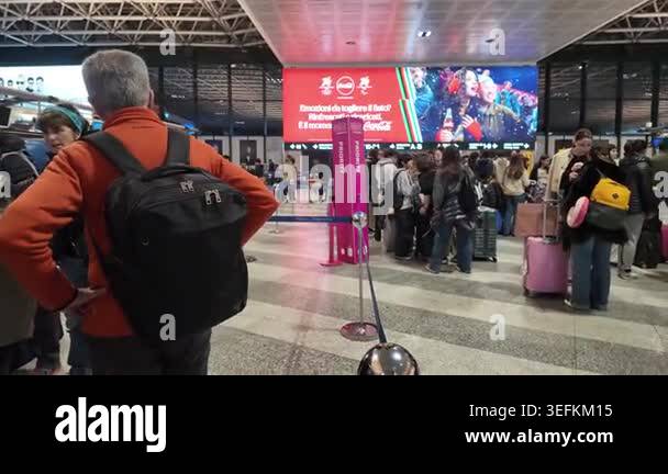 Milan, italy 22 april 2026: travelers with luggage standing in a long ...