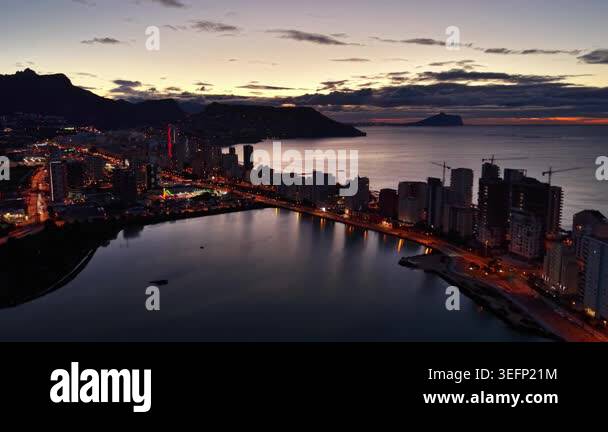 Dawn harbor with glowing bridge lights and reflective lagoon, city ...