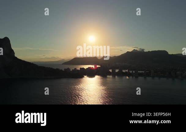 Aerial sunset over Calpe bay skyline and mountain silhouettes on Costa ...