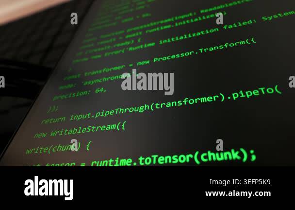 Green source code lines appear and scroll on a dark computer monitor ...