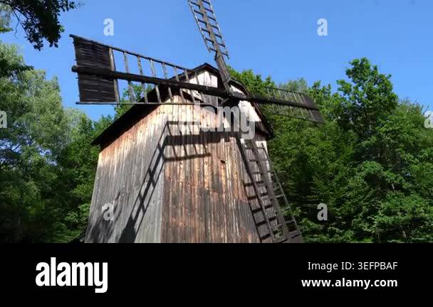 Old working windmill with wooden blades. Historical wooden structure ...
