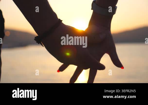 Male and female hands comforting and stroking each other at sunset ...