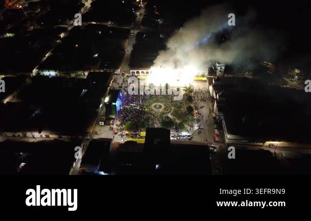 Fireworks explode over a cheering crowd gathered in a city square at ...