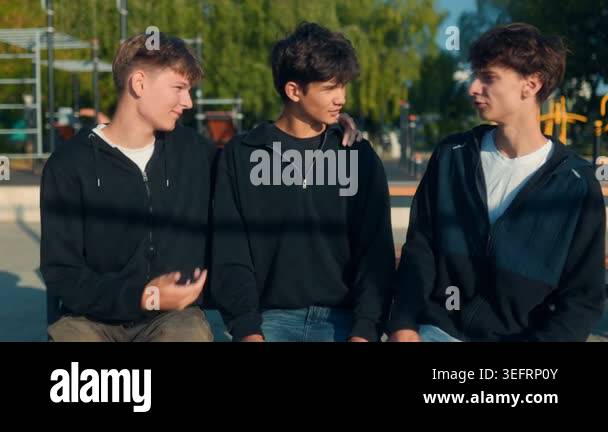 A bright sunny day with three teen boys sharing a laugh and deep talk ...