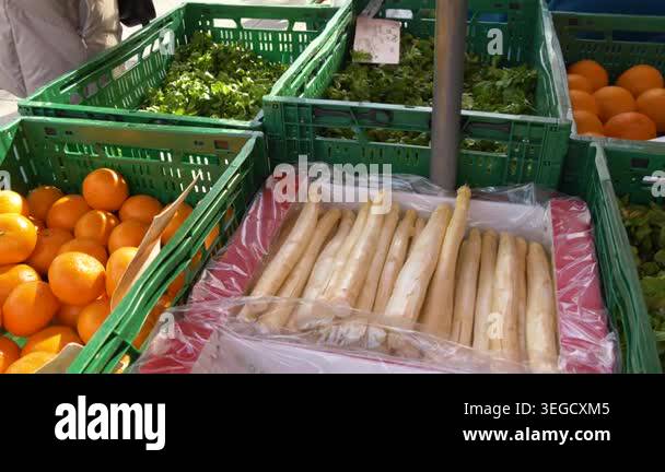 Local market stall with asparagus, leafy greens and citrus fruits with ...