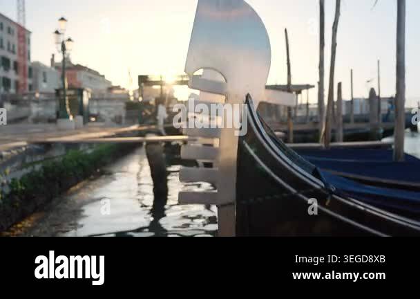 Close-up of traditional Venetian gondolas moored on calm morning water ...