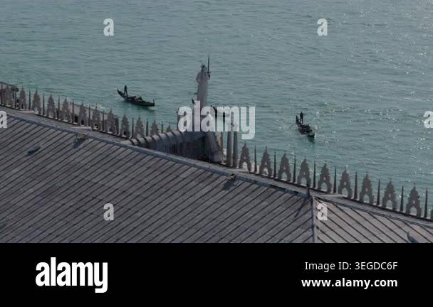 Slow-motion aerial view of gondolas gliding through a bright Venetian ...
