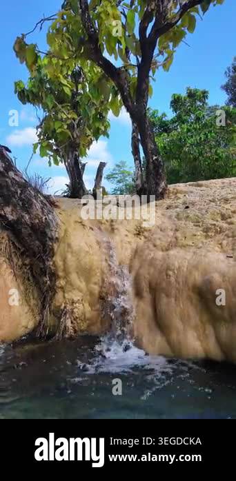 Beautiful tropical waterfall with crystal blue water in a lush green ...