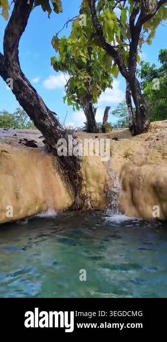 Beautiful tropical waterfall with crystal blue water in a lush green ...