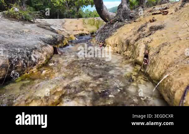 Beautiful tropical waterfall with crystal blue water in a lush green ...