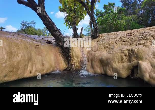 Beautiful tropical waterfall with crystal blue water in a lush green ...