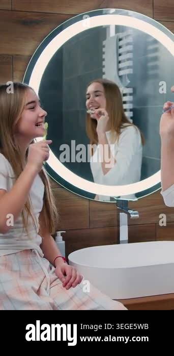 Good-looking of an attractive young woman and her sister brushing their ...