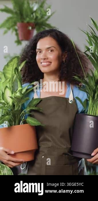 Portrait of cheerful professional gardener African American woman ...