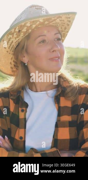 Middle age caucasian woman farmer in hat standing in lavender field ...