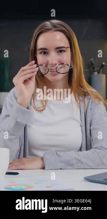 Portrait of beautiful smiling woman sitting the table in glasses ...
