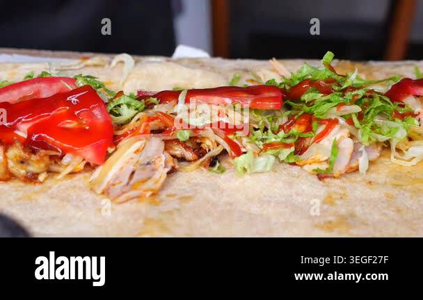Cook prepares shawarma with chicken, tomato, lettuce, and sauce Stock ...