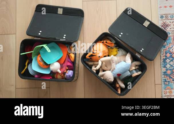Children are playing with various toys from two storage boxes on the ...