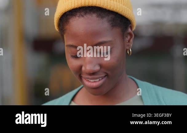 Smiling young Black woman standing outdoors during daytime. Closeup ...