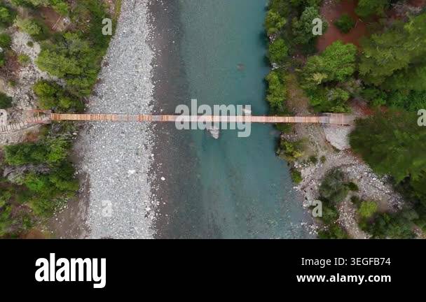 Aerial top-down view of a wooden suspension bridge over the pristine ...