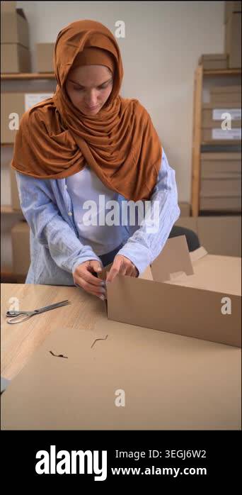 Muslim woman assembling Cardboard box for shipping orders. Working in ...