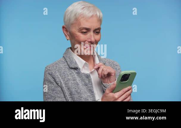 Older woman smiling while using a smartphone, showing modern ...