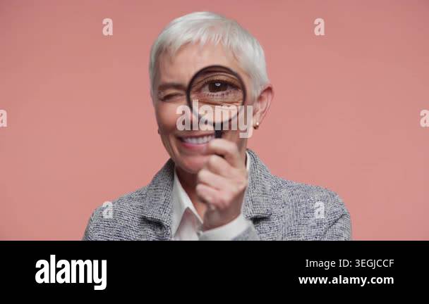 Older woman with short gray hair smiles while looking through a ...