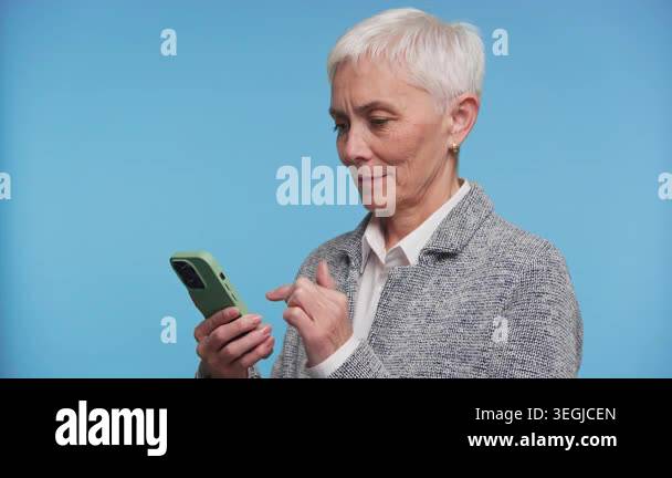 Confident older woman using a smartphone for online browsing ...