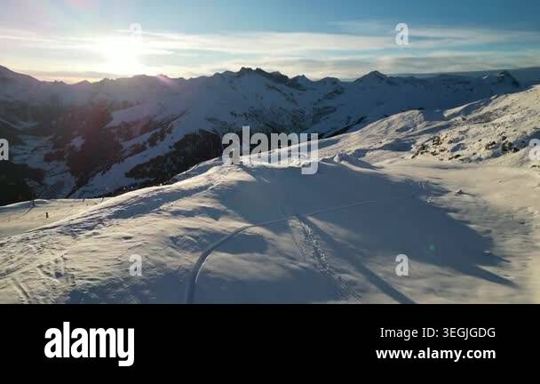 Majestic aerial view flying over a snow covered mountain landscape ...