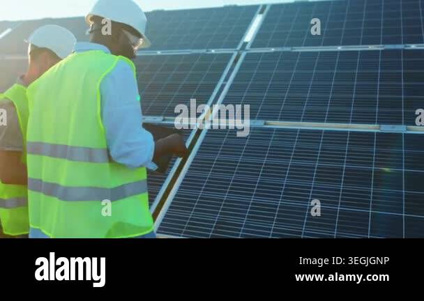 technicians test solar panel performance with diagnostic laptop, two ...