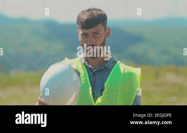 Caucasian engineer inspecting outdoor construction site, wearing white ...