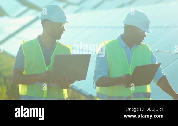 engineers reviewing solar site data on laptops, collaborative ...
