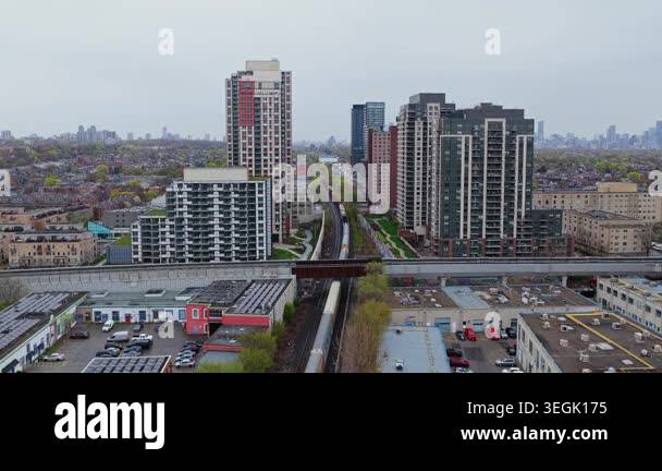 Commuter train passing through modern apartment buildings in Toronto ...