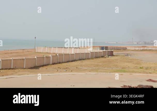 Hazy coastal landscape of Accra, Ghana, empty plot of land enclosed by ...