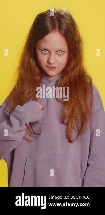 I am watching you. Young cute redhead school girl pointing at her eyes ...
