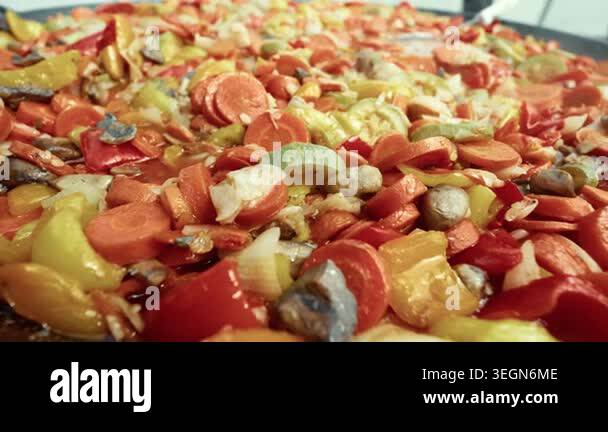 Chopped vegetables like carrots, bell peppers, and onions are sizzling ...