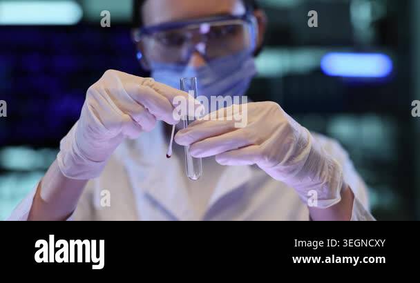 Female scientist puts swab with blood drop sample into test tube in lab ...