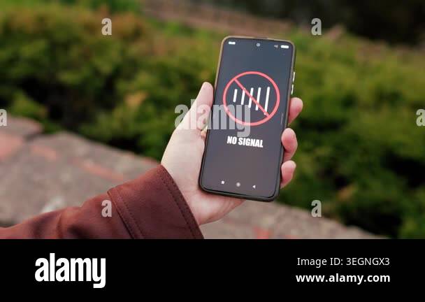 4K video of a hand holding a smartphone outdoors with a No Signal icon ...