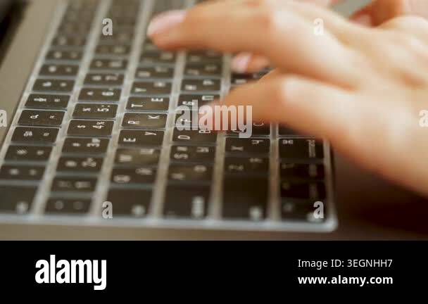 Woman's hands type rapidly on a laptop keyboard at a desk. Clear ...