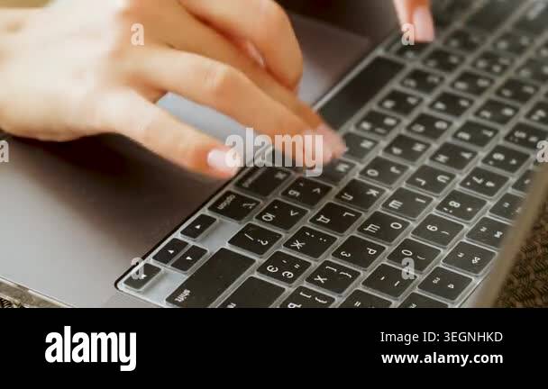 Person's hands actively typing on laptop keyboard with transparent ...